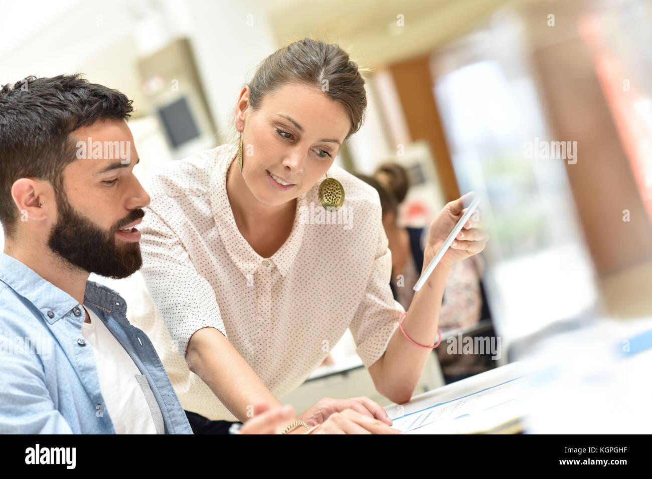 Colleagues in office checking agenda Stock Photo - Alamy