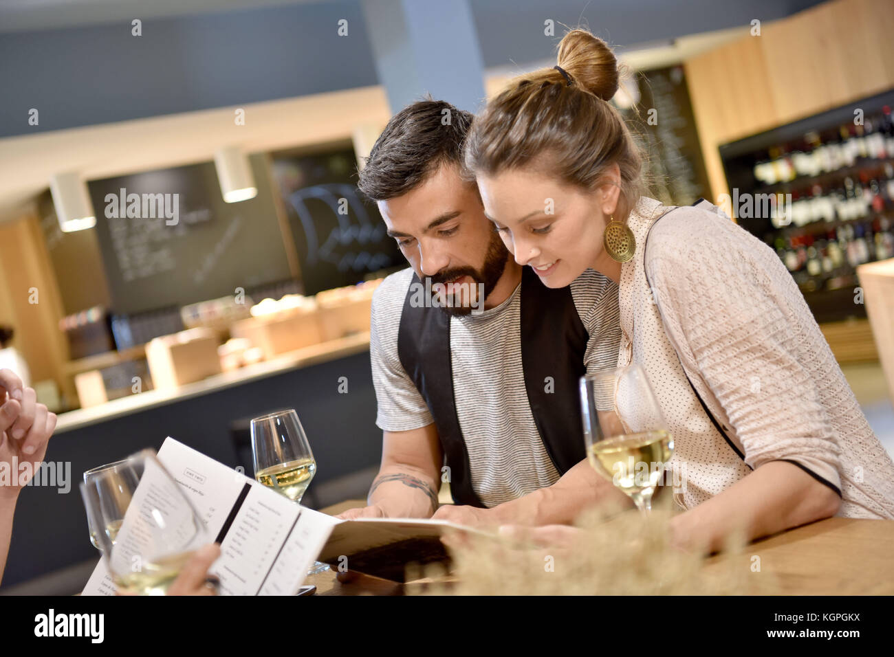 Young trendy people in restaurant looking at menu Stock Photo - Alamy