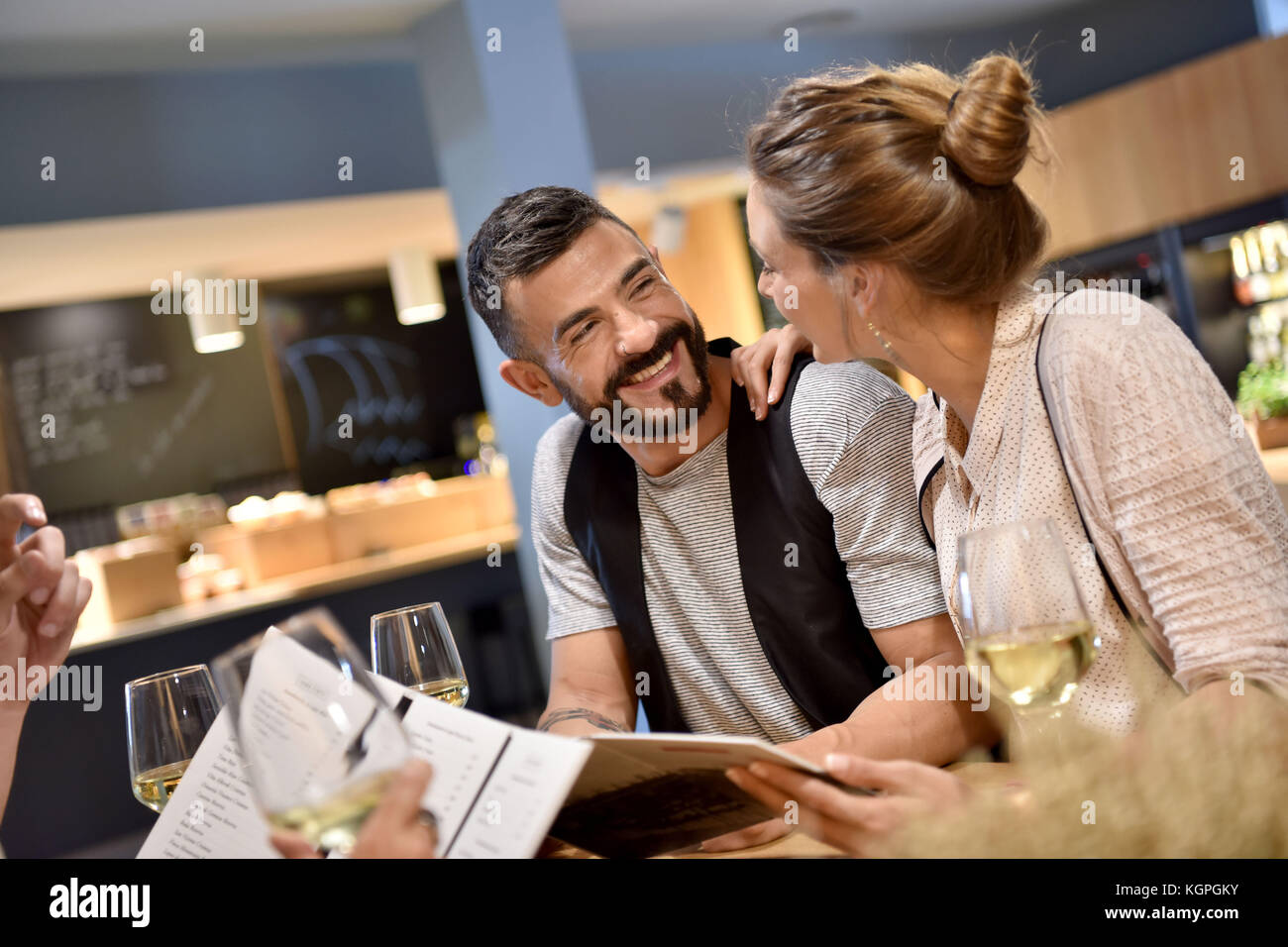 Young trendy people in restaurant looking at menu Stock Photo - Alamy