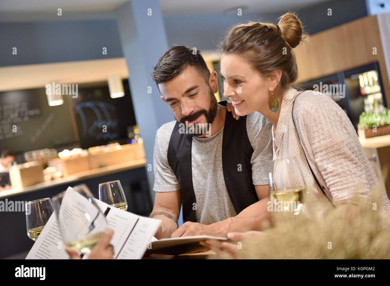 Young trendy people in restaurant looking at menu Stock Photo - Alamy