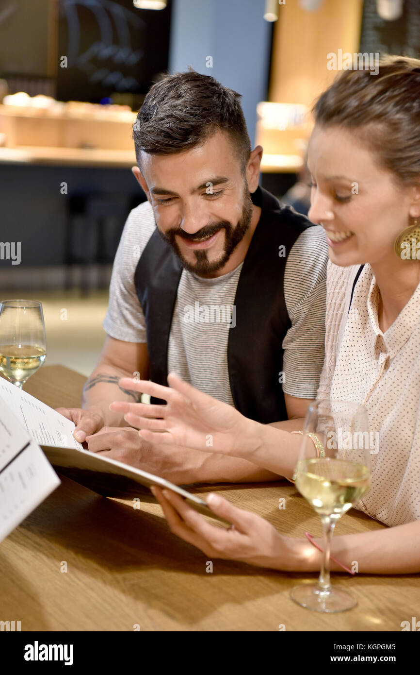 Young trendy people in restaurant looking at menu Stock Photo - Alamy