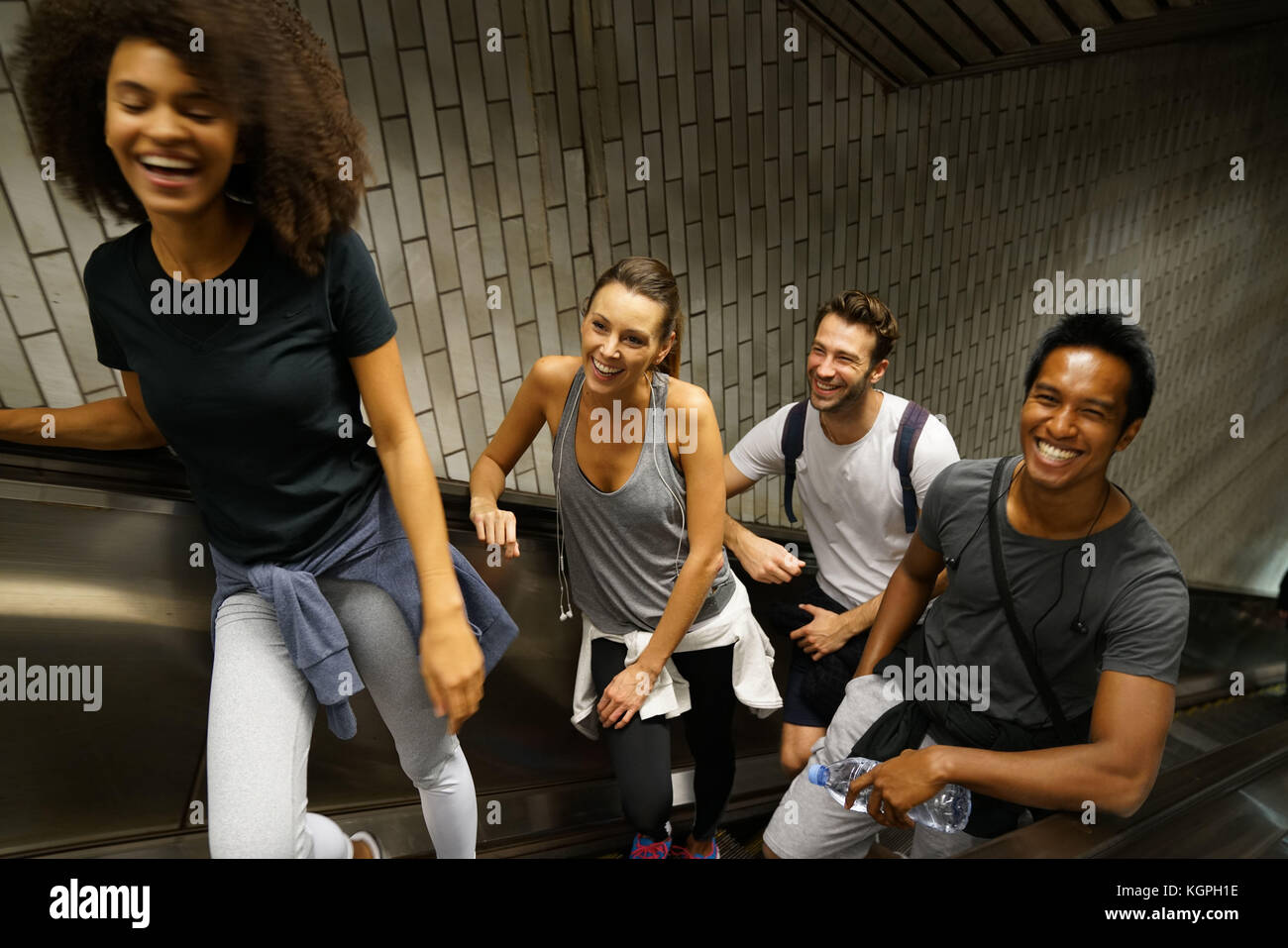 Group of friends having fun in subway stairs Stock Photo - Alamy