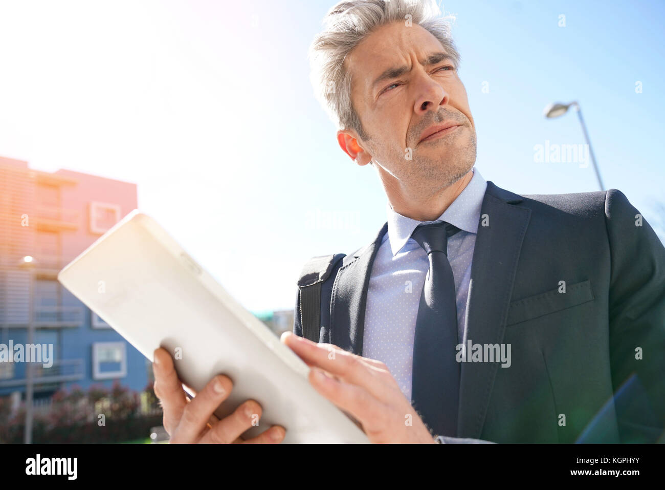 Businessman working on digital tablet in front of office building Stock ...