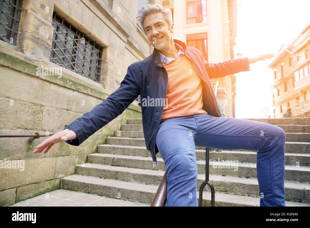 Man having fun sliding down staircase ramp Stock Photo - Alamy