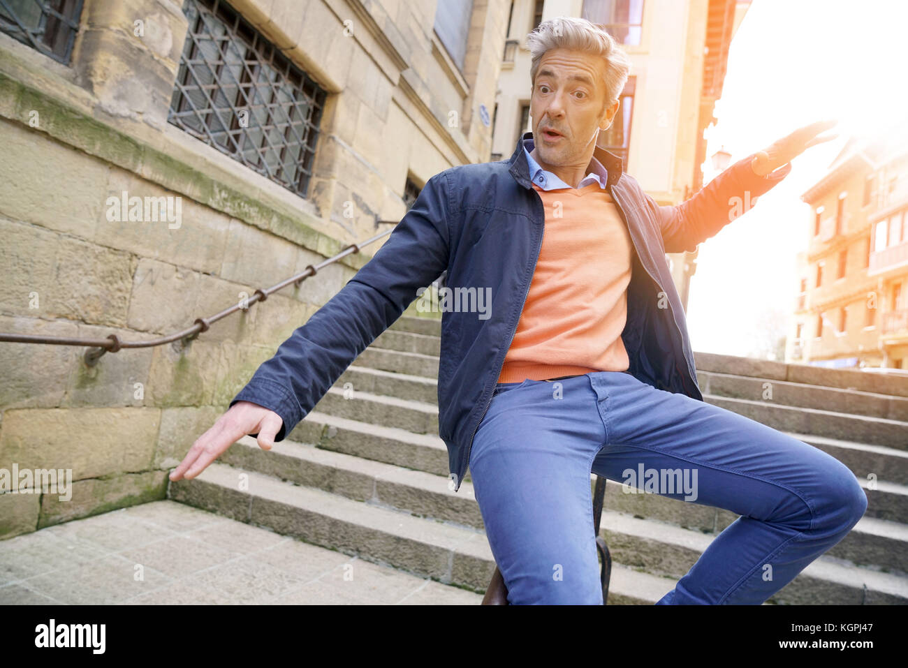 Man having fun sliding down staircase ramp Stock Photo - Alamy