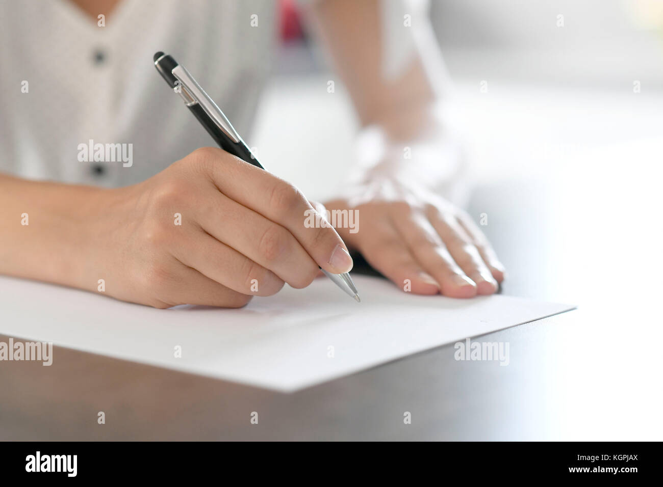 Closeup of woman's hand writing on paper with pen Stock Photo - Alamy