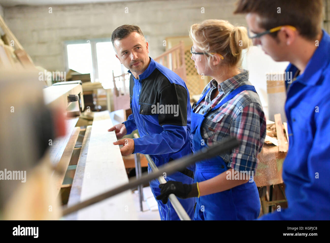 Professional teacher showing carpentry machinery to students Stock ...