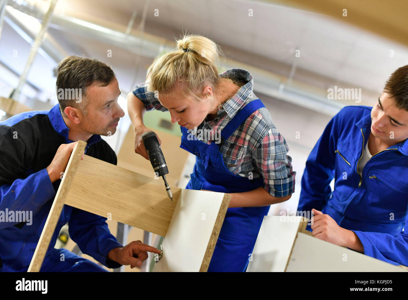 Carpenter with students in workshop assembling wood Stock Photo - Alamy
