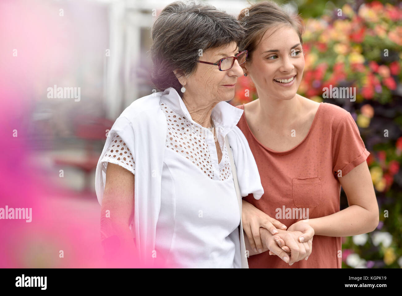 Home carer helping disabled woman walking with crutch Stock Photo - Alamy