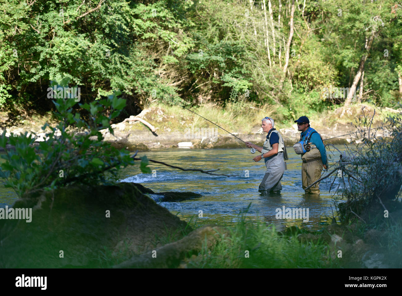 Flyfisherman with fishing guide in river Stock Photo - Alamy