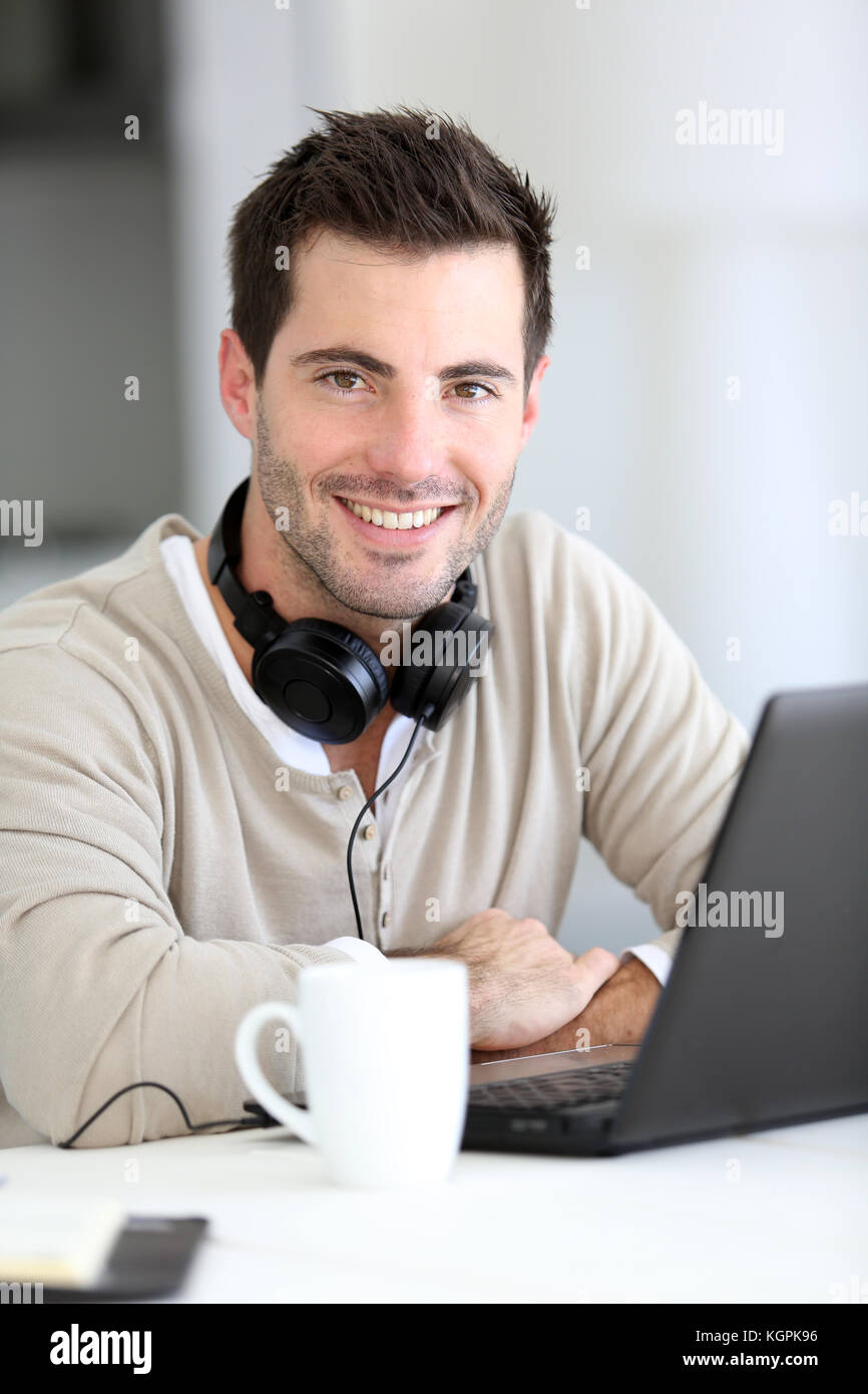 Man in front of laptop computer with headset Stock Photo - Alamy