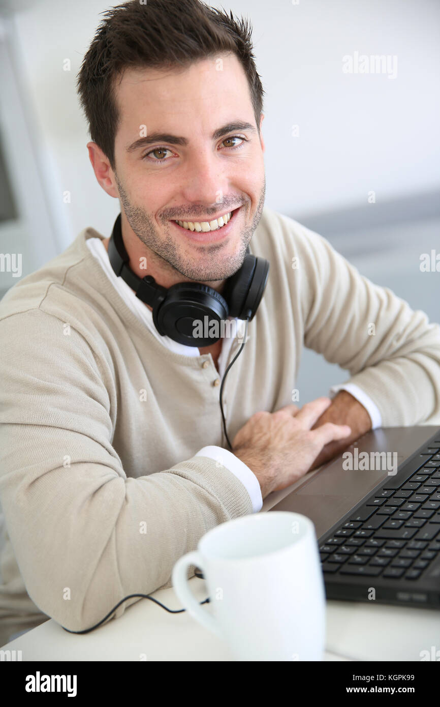 Man in front of laptop computer with headset Stock Photo - Alamy