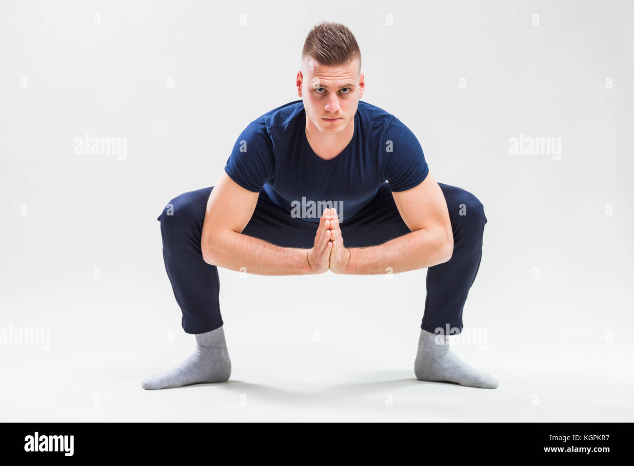 Studio shot image of young man who is stretching his body. Utatasana ...