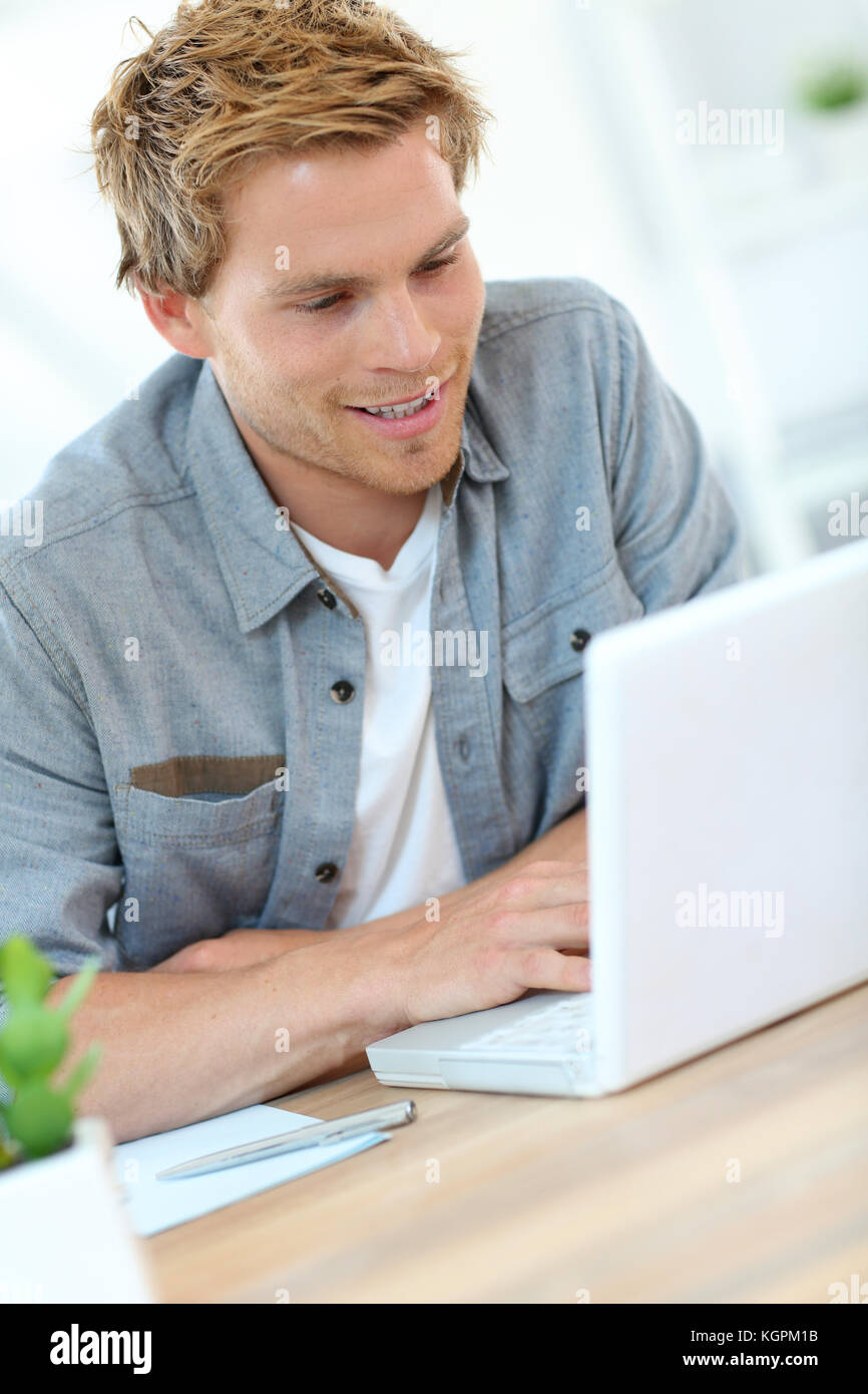 Young man in office working on laptop computer Stock Photo - Alamy