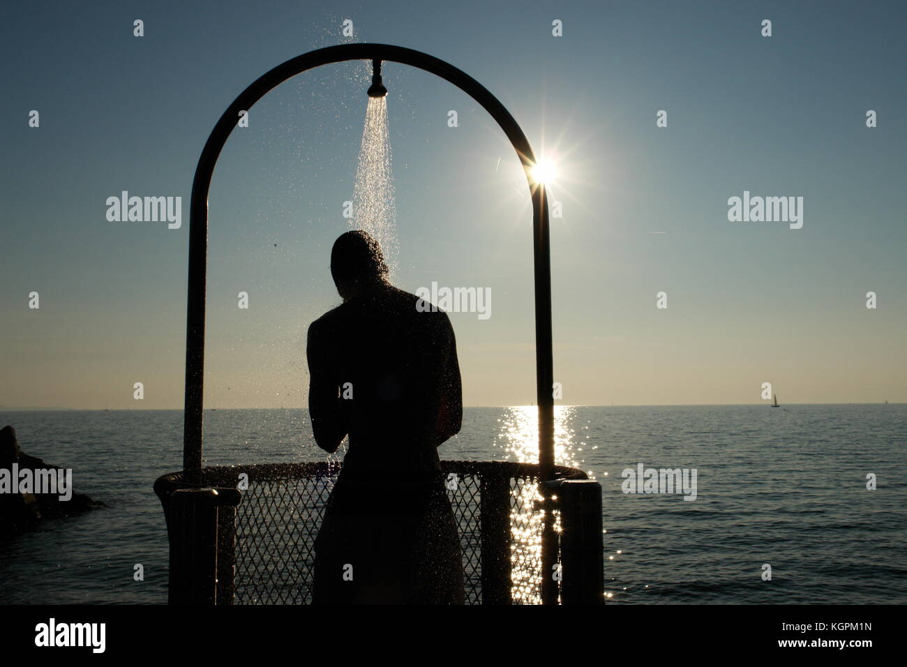 Man showering overlooking the ocean Stock Photo - Alamy