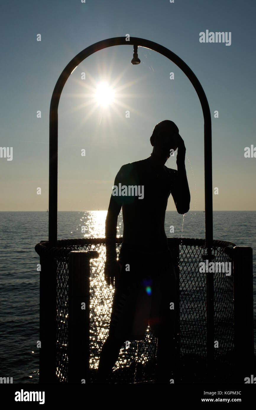 Man finishing an open air shower dripping water Stock Photo - Alamy