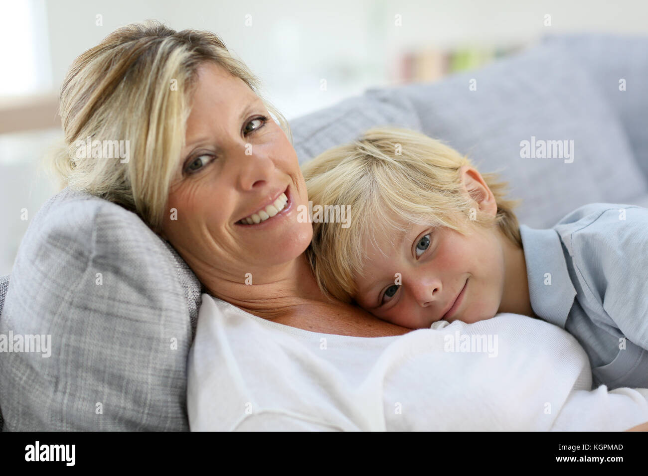 Portrait of happy mom and son relaxing on couch Stock Photo - Alamy