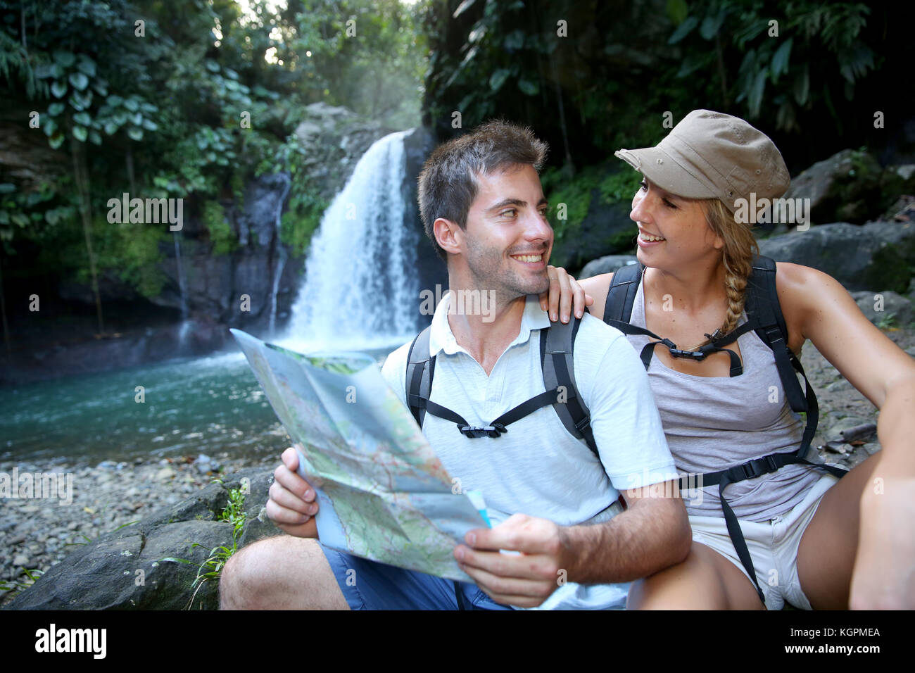 Hikers looking at map by waterfall Stock Photo - Alamy