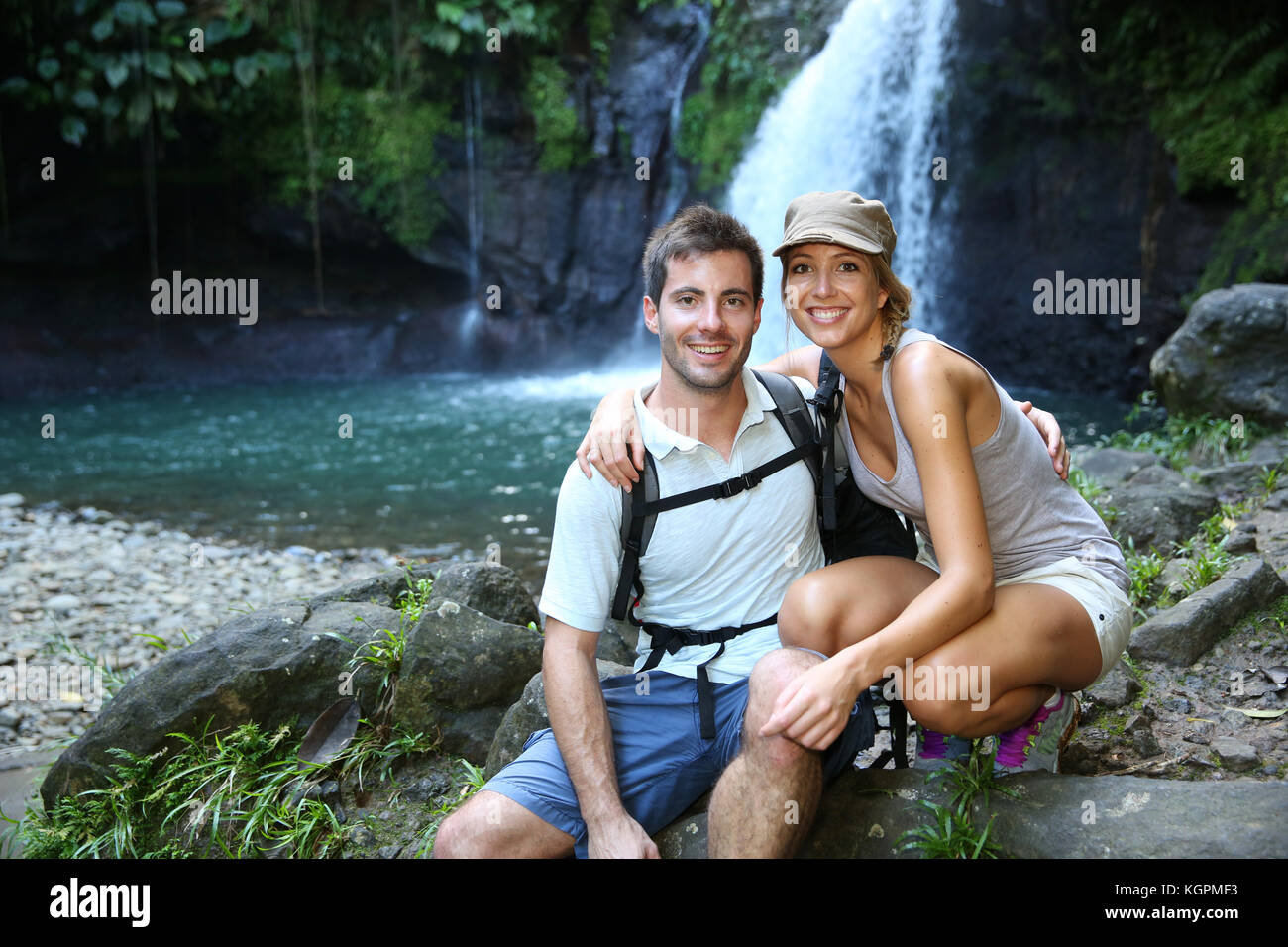 Trekkers reaching waterfall in natural landscape Stock Photo - Alamy