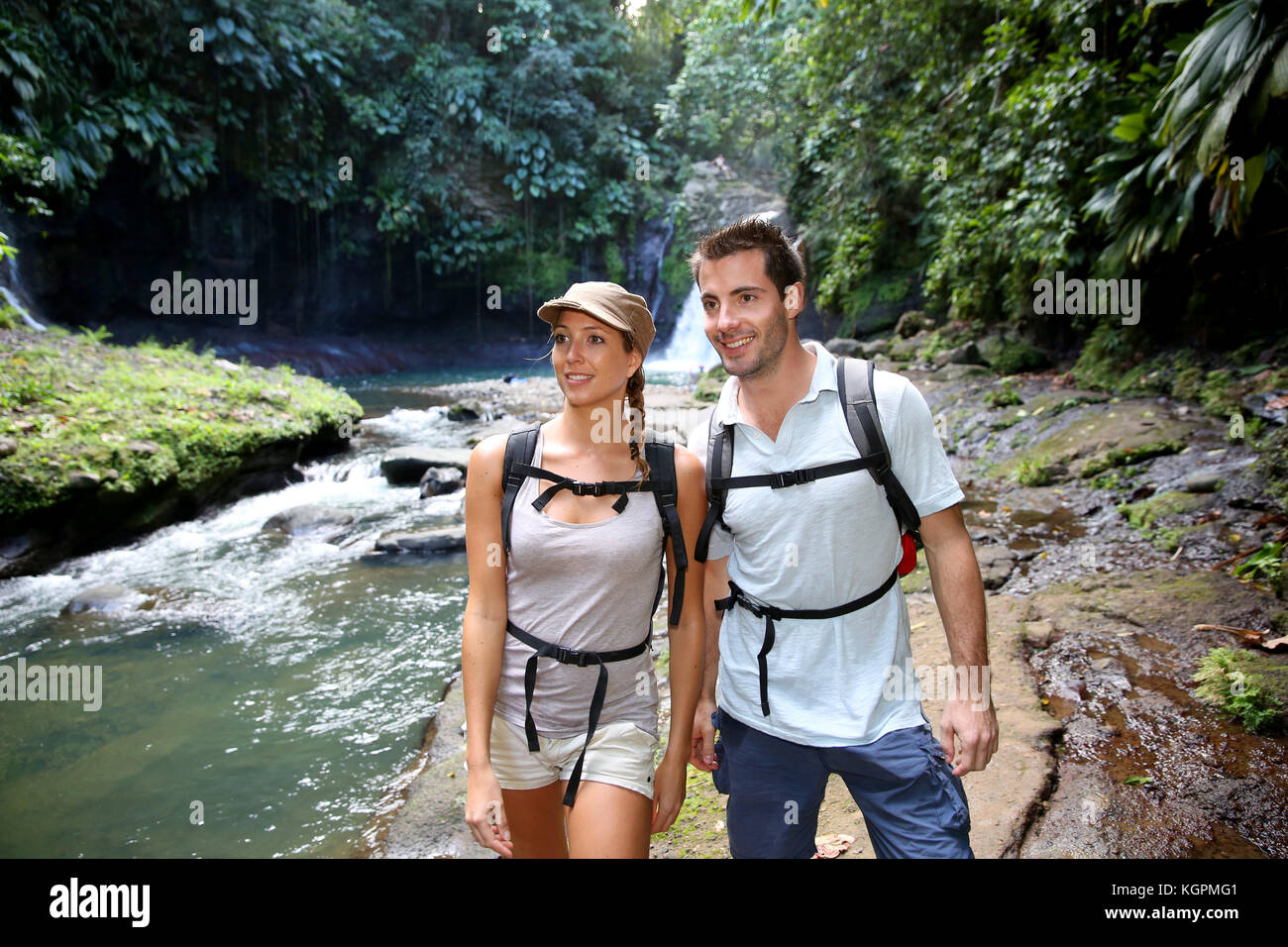 Trekkers reaching waterfall in natural landscape Stock Photo - Alamy