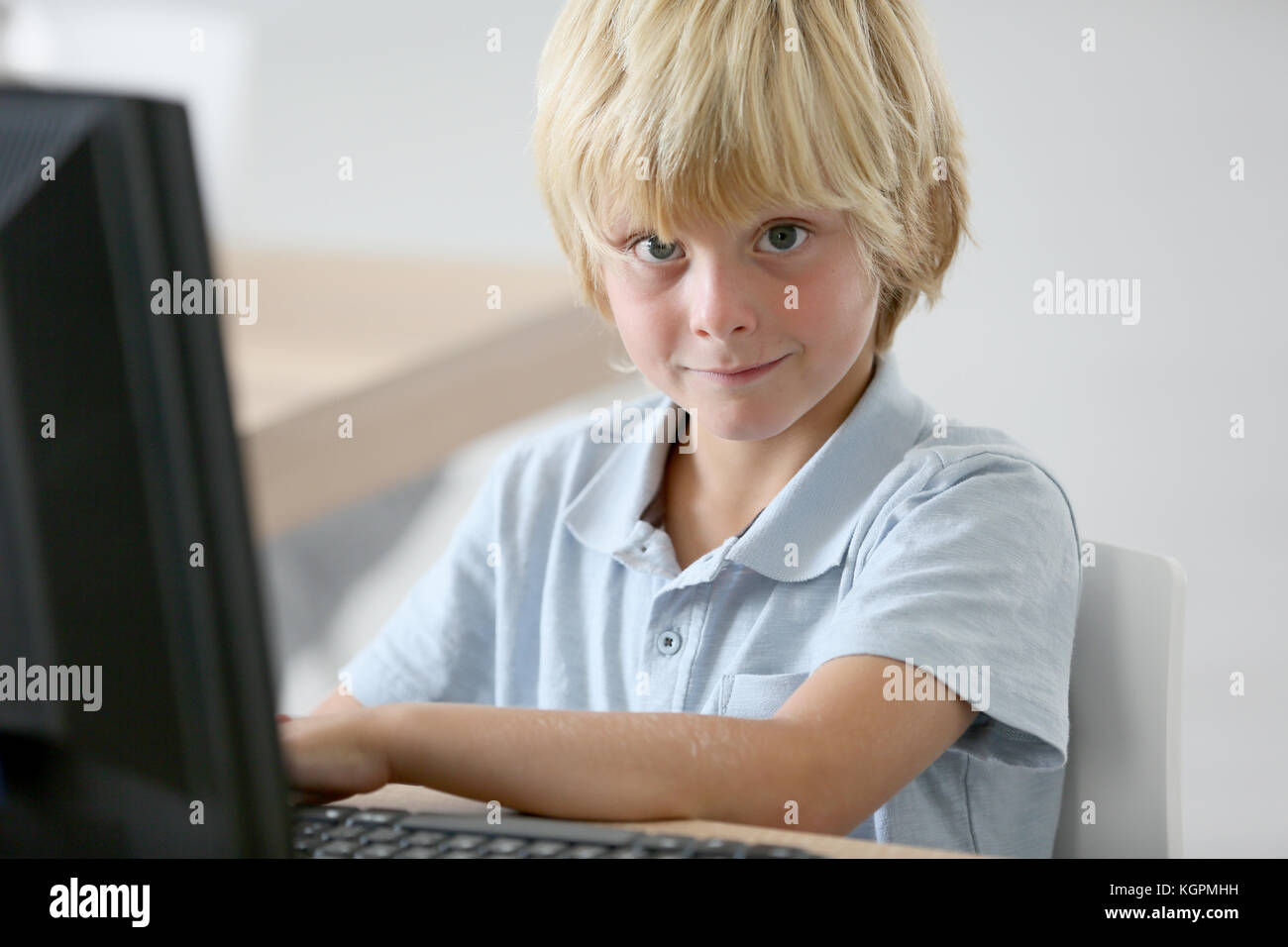 Portrait of school boy sitting in front of computer Stock Photo - Alamy