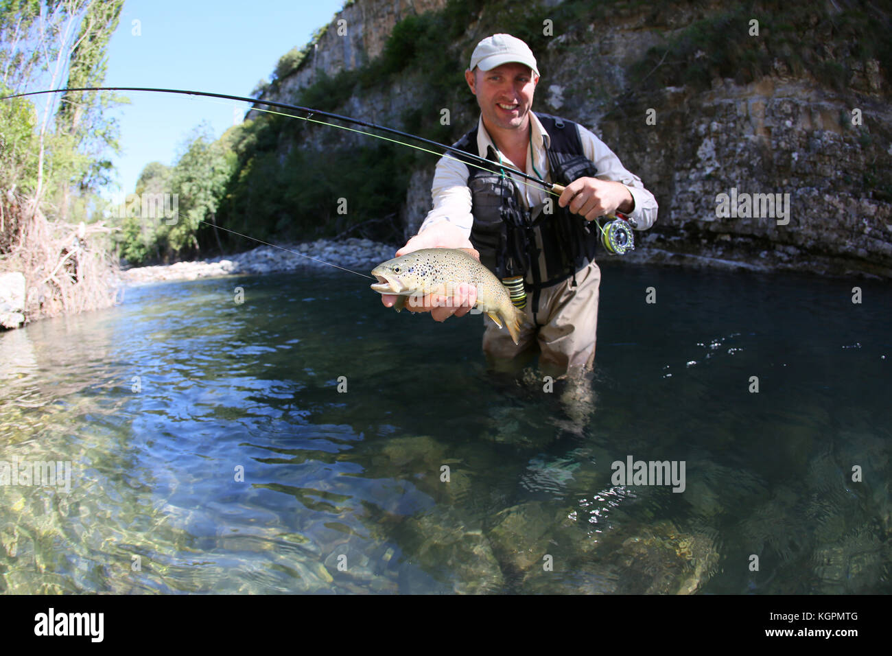 Fly fisherman catching a fario trout in river Stock Photo - Alamy