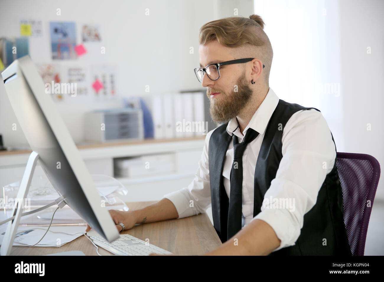 Young man in office working on desktop computer Stock Photo - Alamy