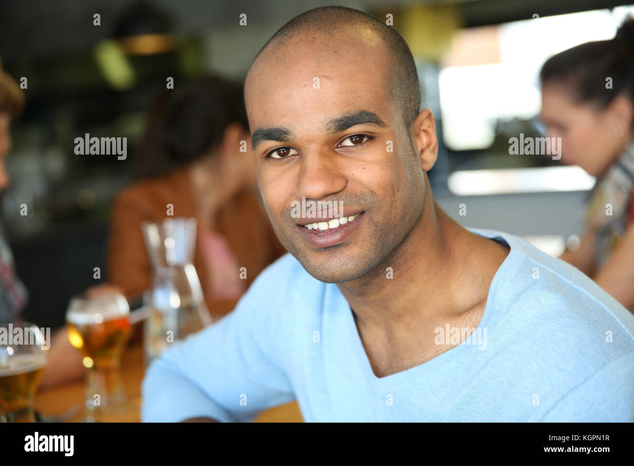 Smiling mixed-raced man sitting in snack bar Stock Photo - Alamy