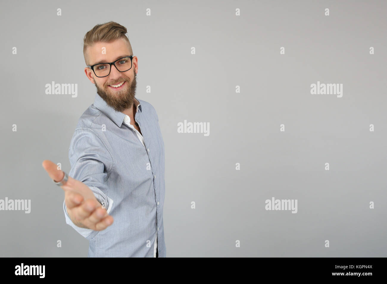 Smiling trendy guy giving hand for handshake Stock Photo - Alamy