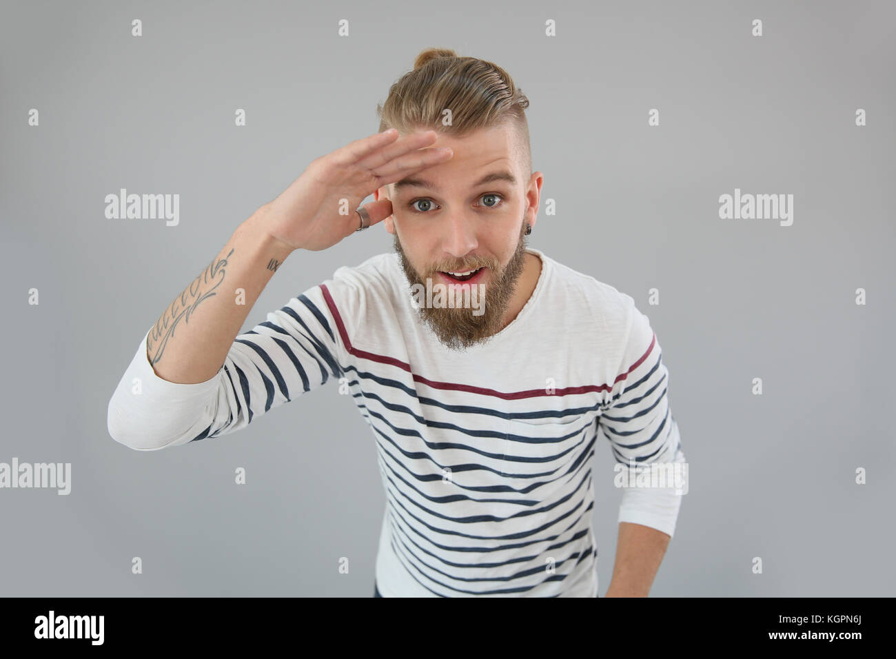 Portrait of trendy guy looking away, hand on forehead Stock Photo - Alamy