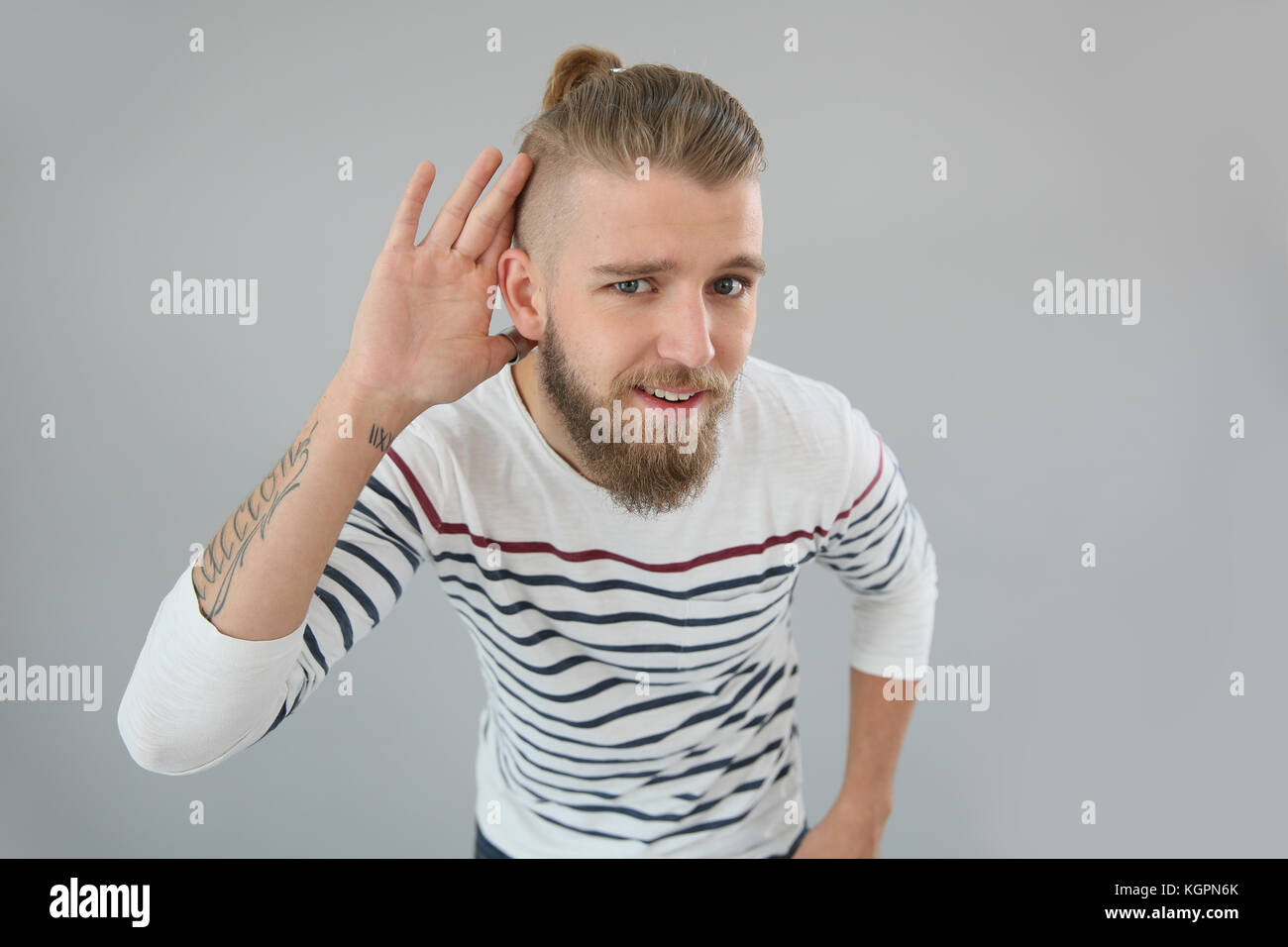 Man prinking up his ear to listen better Stock Photo - Alamy