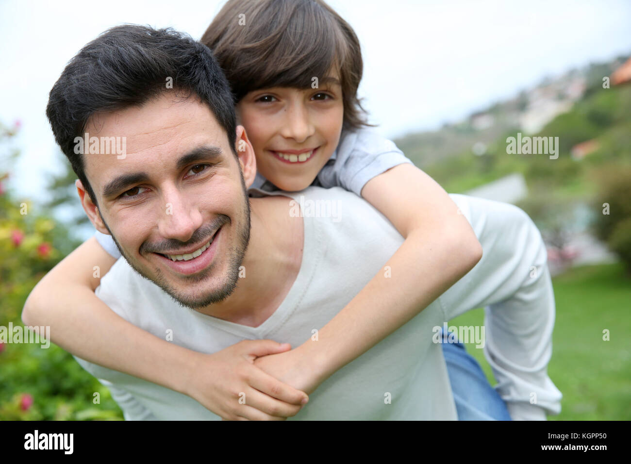 Father giving piggyback ride to his son Stock Photo - Alamy