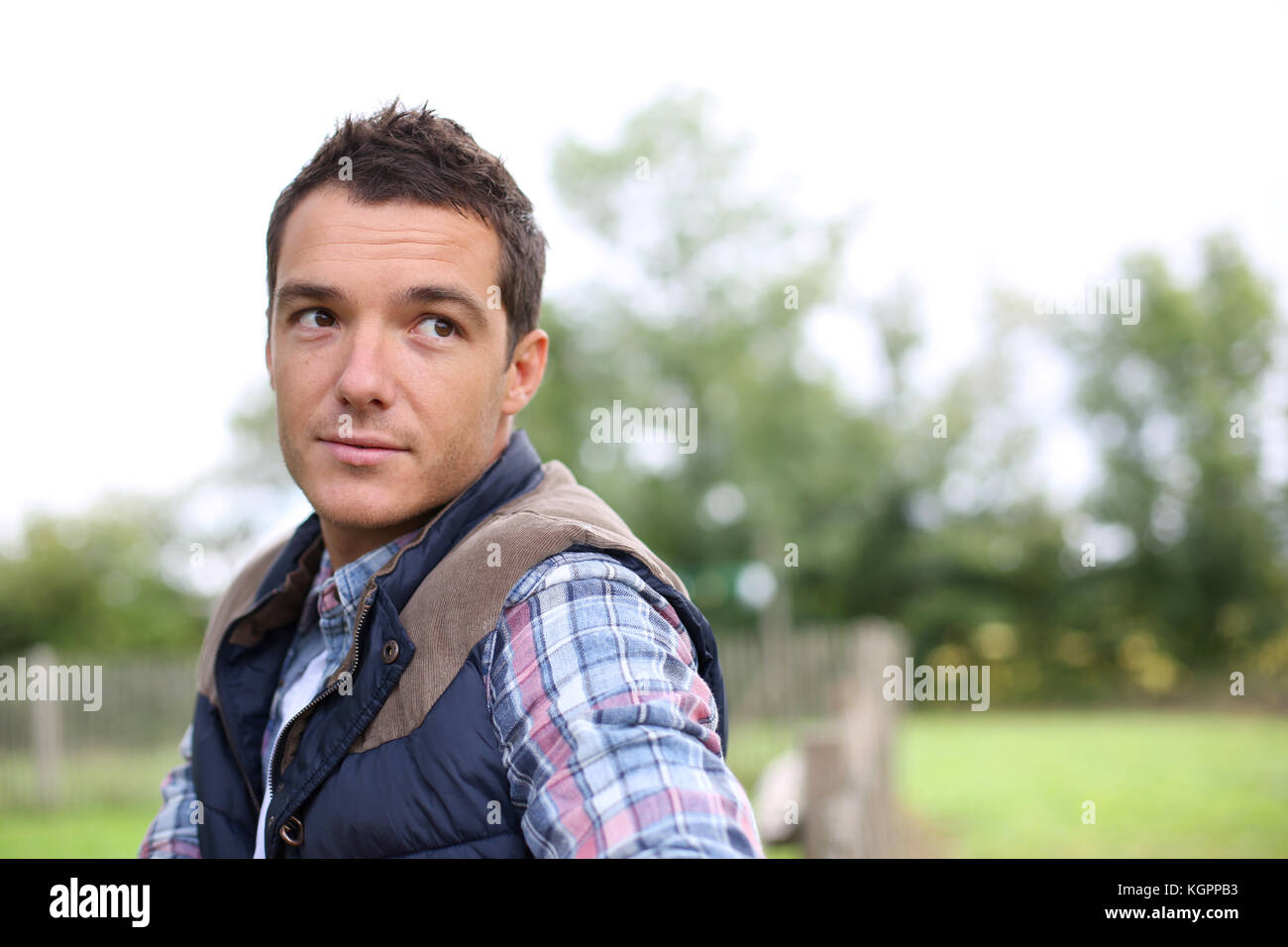 Man in countryside leaning on fence Stock Photo - Alamy