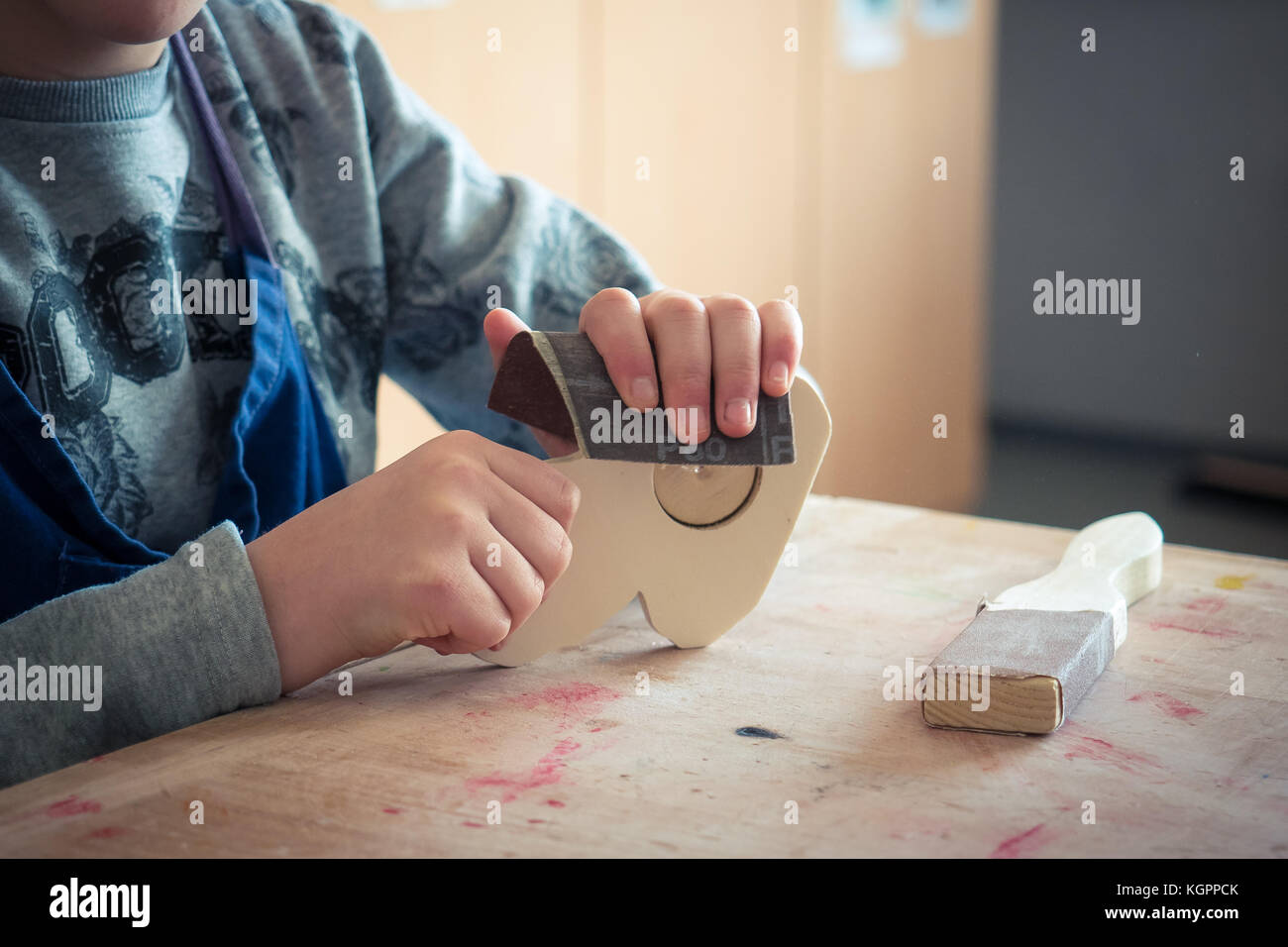 Kid working with wood and sandpaper Stock Photo - Alamy