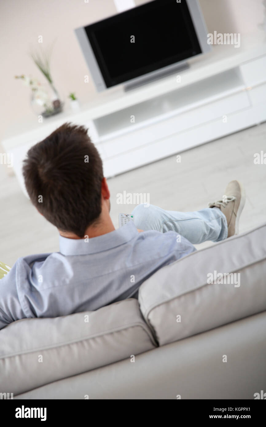 Back view of man in couch watching TV Stock Photo - Alamy