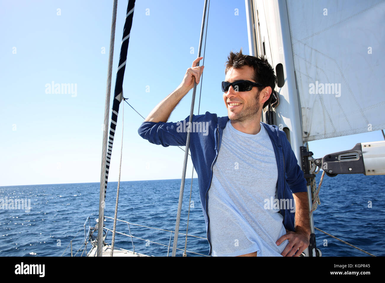 Skipper standing on sailboat while sailing Stock Photo - Alamy