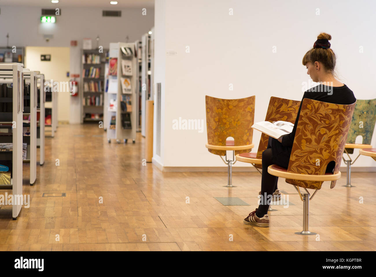 A woman sitting and reading in a library in Sweden Stock Photo - Alamy
