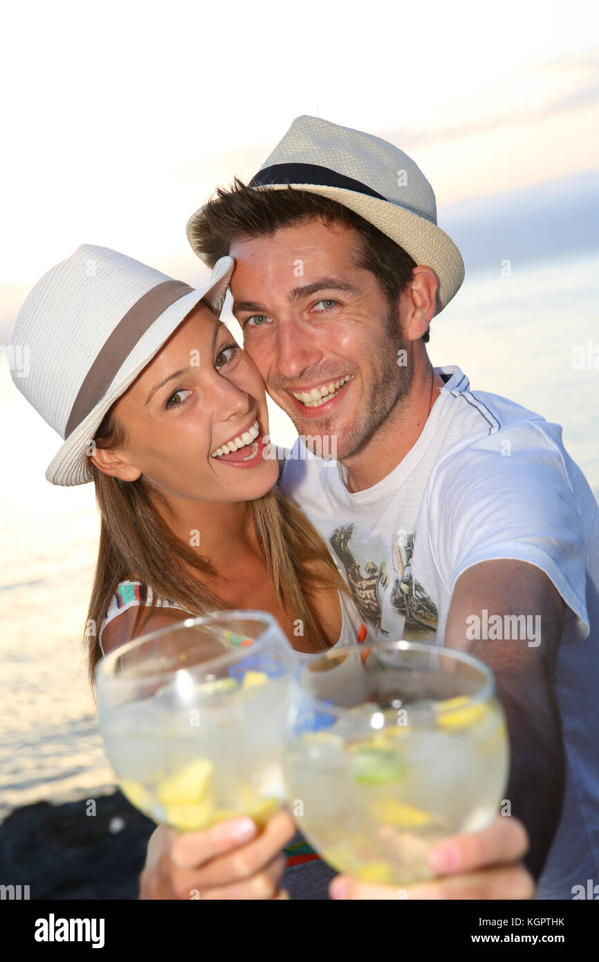 Couple enjoying cocktail drinks at sunset time Stock Photo - Alamy