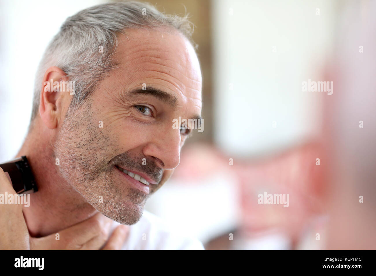 Senior man shaving beard with electric razor Stock Photo - Alamy