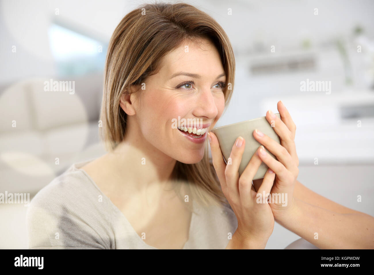 Beautiful woman drinking hot tea Stock Photo - Alamy