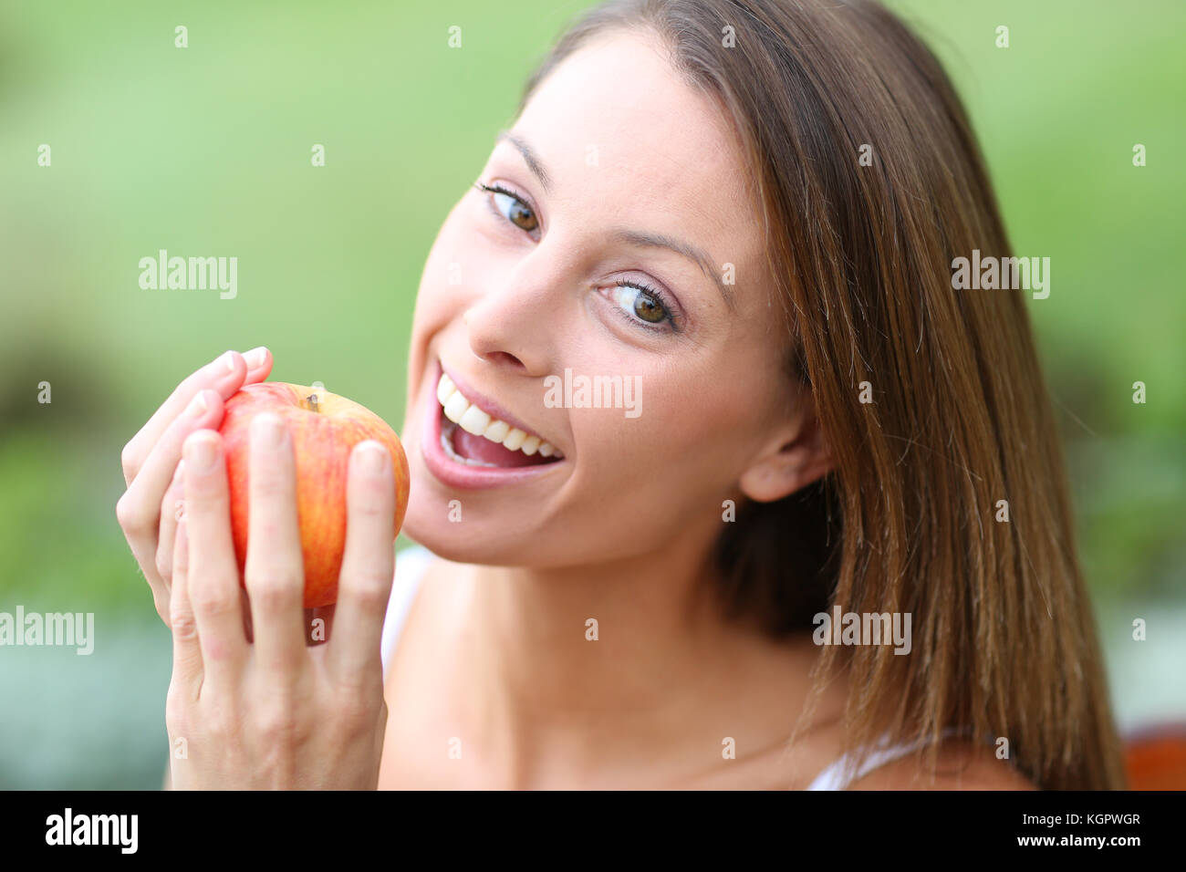 Beautiful girl eating red apple Stock Photo - Alamy