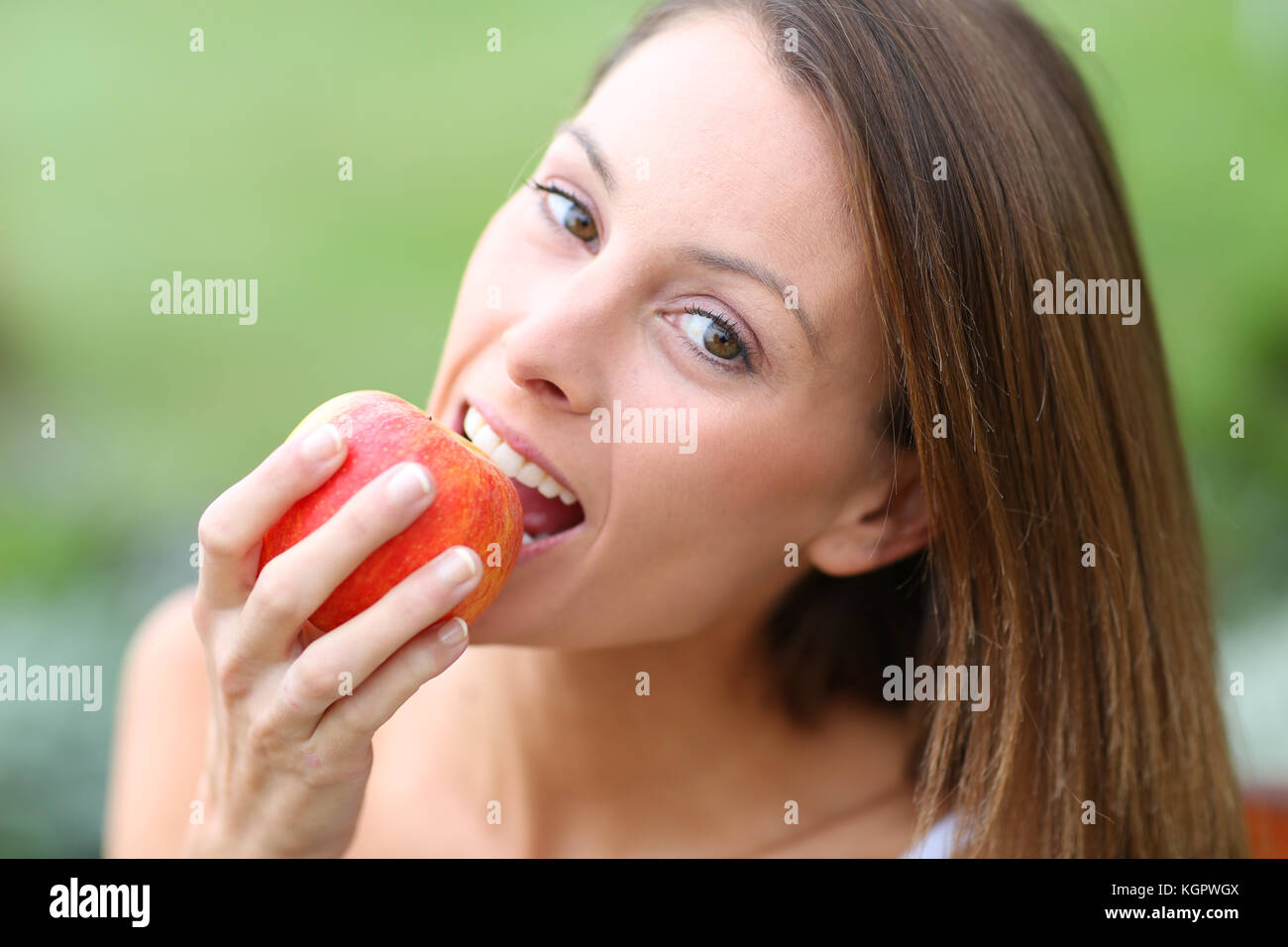 Beautiful girl eating red apple Stock Photo - Alamy