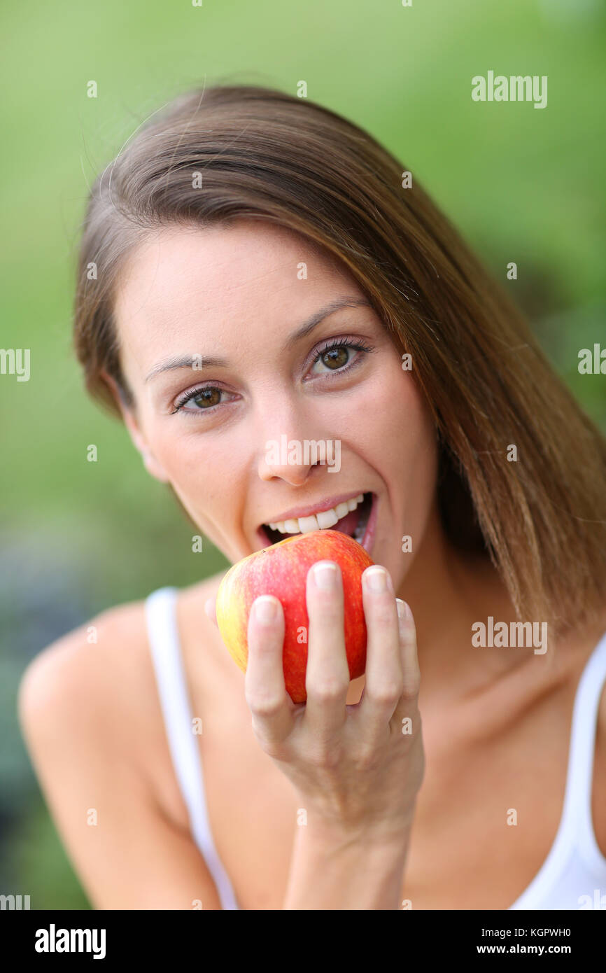 Beautiful girl eating red apple Stock Photo - Alamy