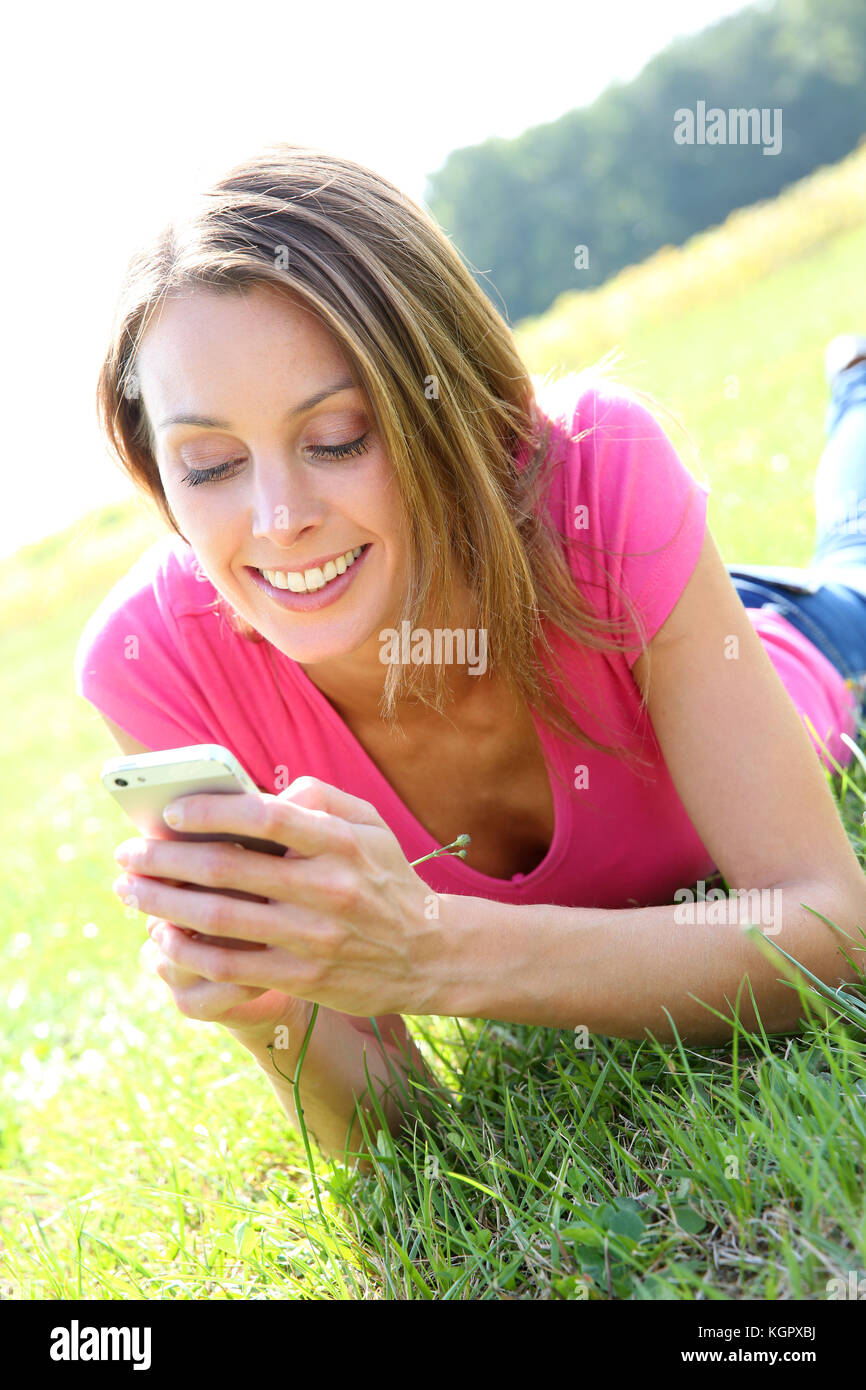 Cheerful girl sending message with smartphone Stock Photo - Alamy