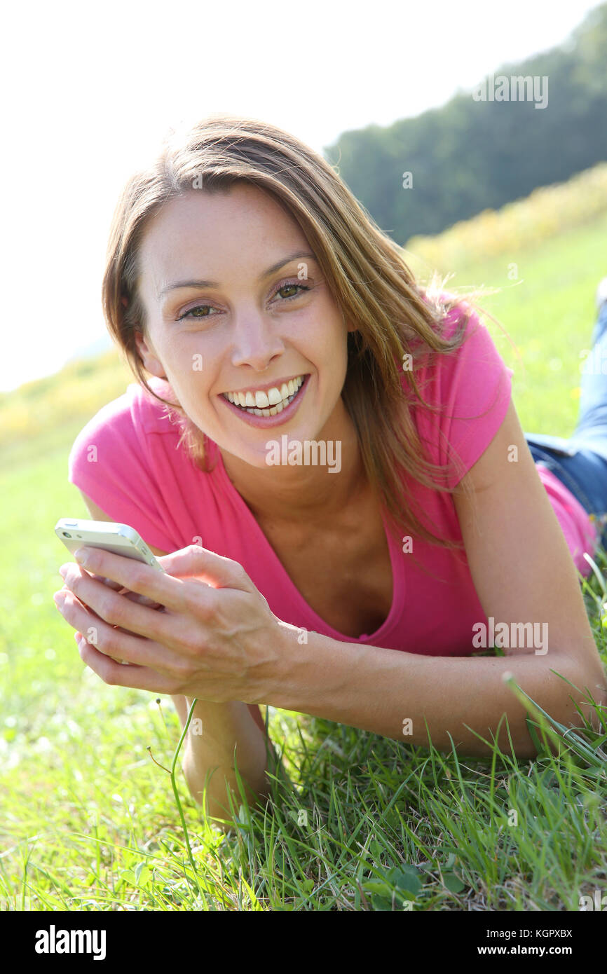 Cheerful girl sending message with smartphone Stock Photo - Alamy