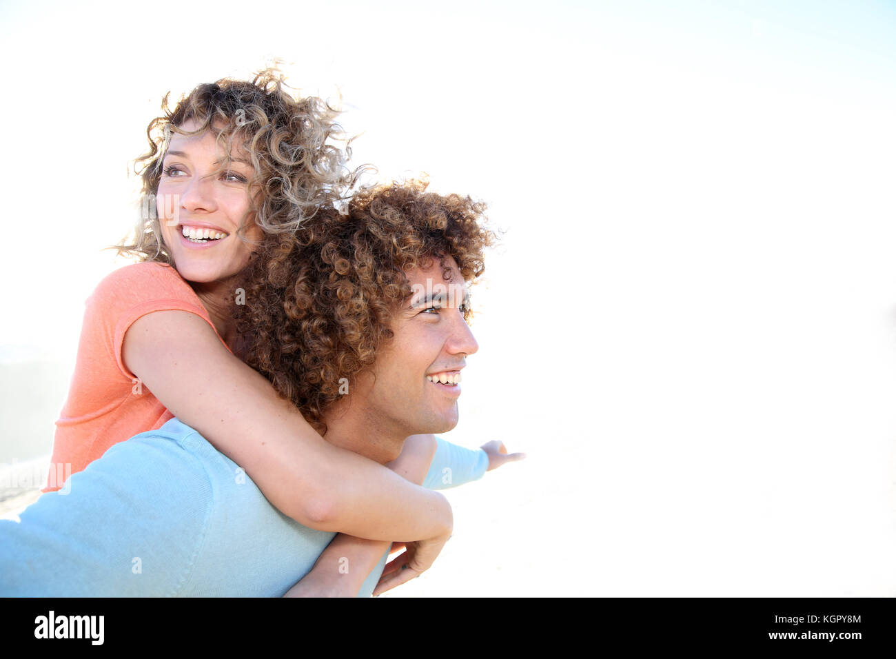 Man giving piggyback ride to girlfriend on the beach Stock Photo - Alamy