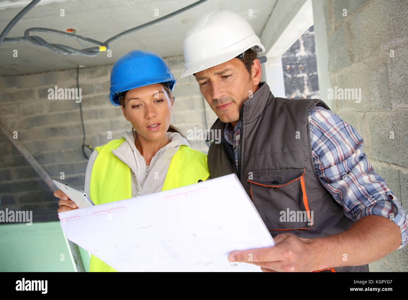 Engineers on building site checking plans Stock Photo - Alamy
