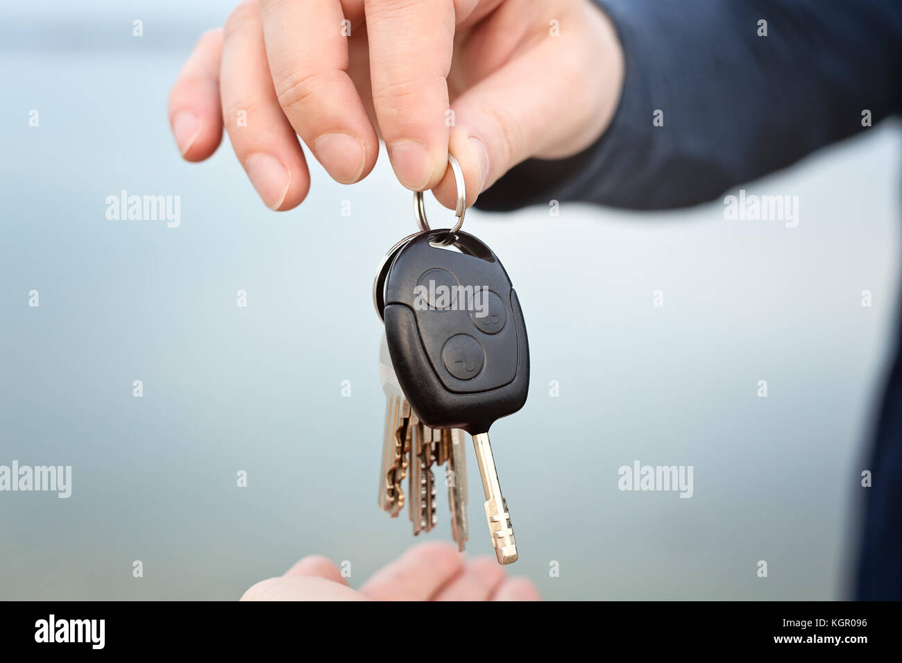 Male hand giving car and house keys to female Stock Photo - Alamy