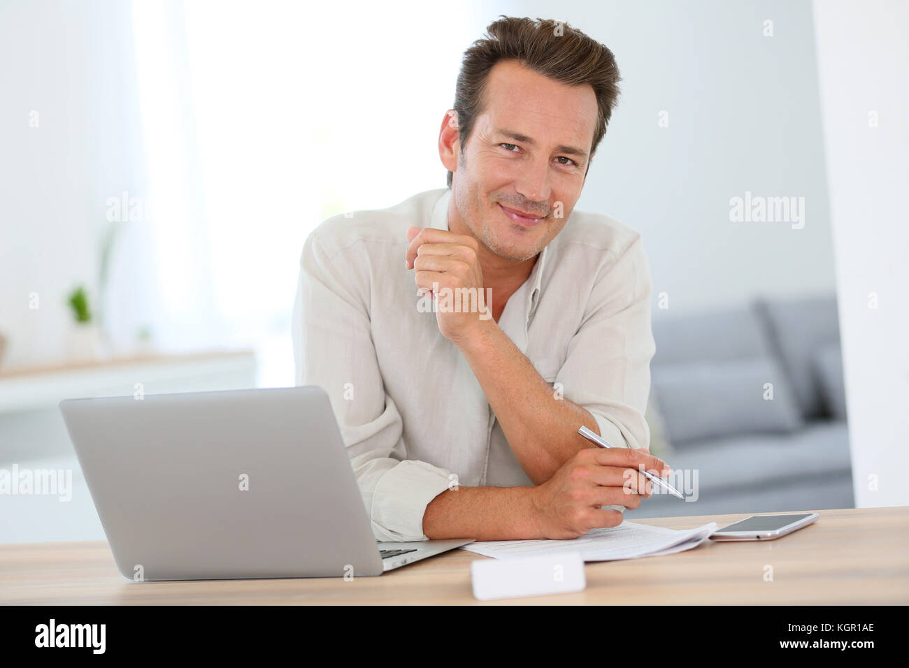 Smiling attractive man working from home Stock Photo - Alamy