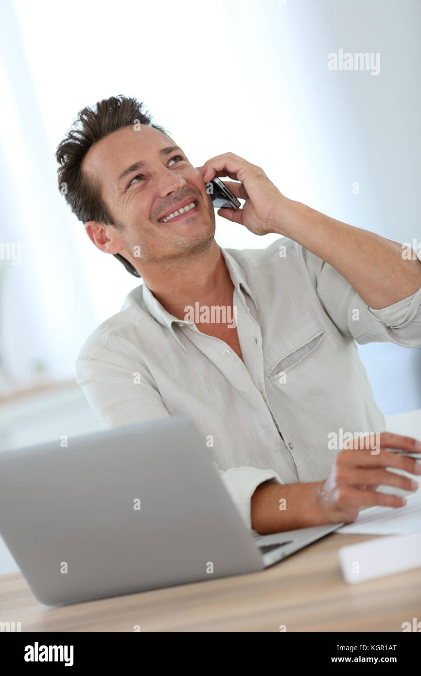 Salesman working from home and talking on phone Stock Photo - Alamy